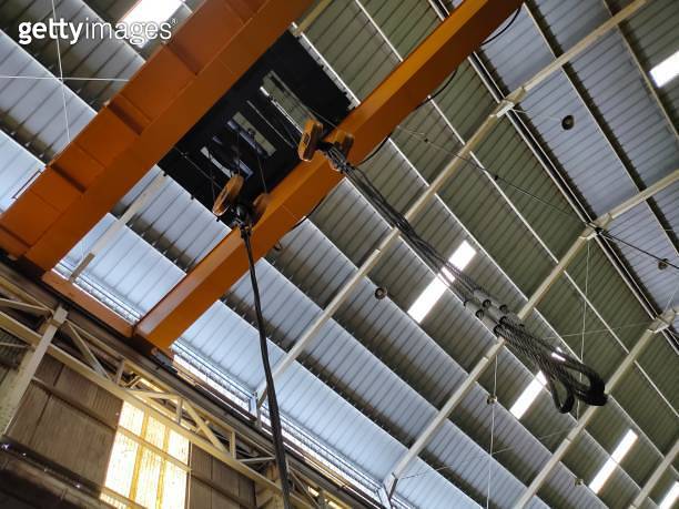 Yellow overhead crane installed on the manufacturing industry plant ...