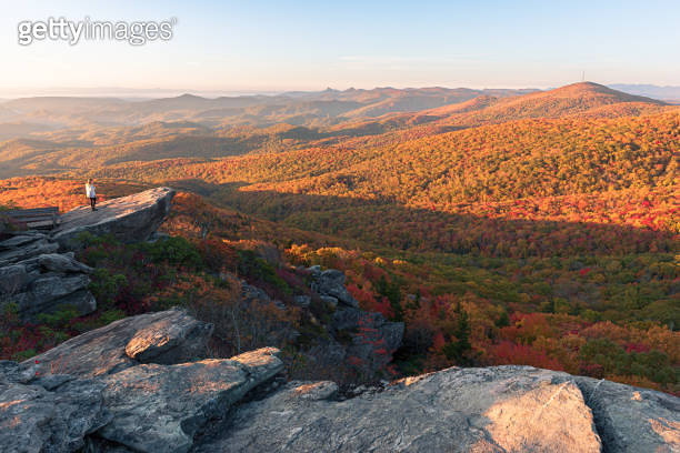 Woman stands on the cliff at Rough Ridge Lookout , Blue Ridge Parkway ...