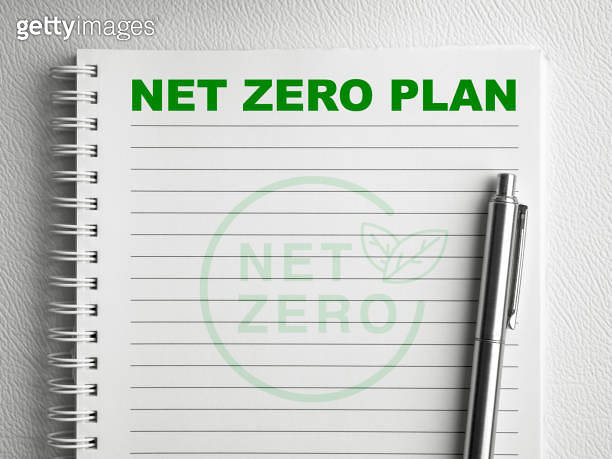 Green text Net Zero Plan on the top of blank vertical notepad page with ...