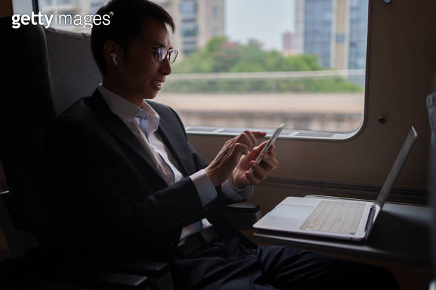 Business men using smartphones on trains 이미지 (1550175209) - 게티이미지뱅크