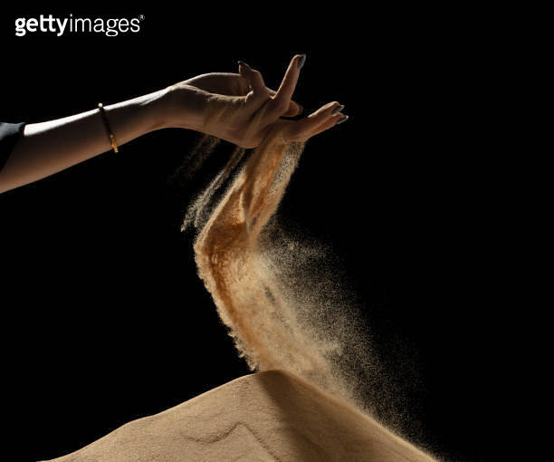 Hand releasing dropping sand on hill. Fine Sand flowing pouring through ...