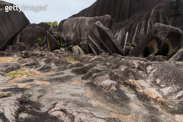 Landscape with the black monolith of the Giant Union Rock. La Digue ...