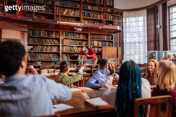Joyful students throwing paper at teacher. 이미지 (1488147070) - 게티이미지뱅크