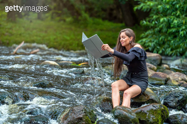 worried woman pulls out of water laptop that fell into river, remote ...