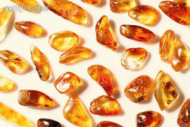Amber stones on beige background, transparent stone yellow beige ...