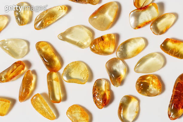 Amber stones at sunlight on light background, stone yellow beige color ...