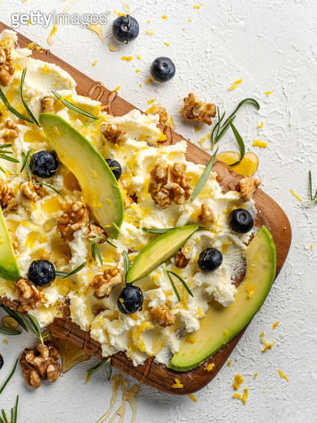 Cream on cutting board. Cream board topped with avocado, blueberry ...