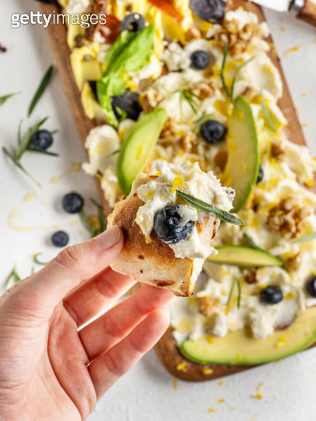 Cream on cutting board. Cream board topped with avocado, blueberry ...