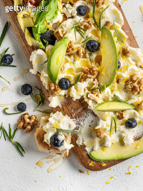 Cream on cutting board. Cream board topped with avocado, blueberry ...