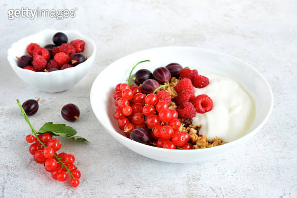 muesli with raspberry, gooseberry, red currant and yogurt in white ...