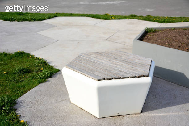 white hexagon bench isolated on concrete pathway in public park, close ...