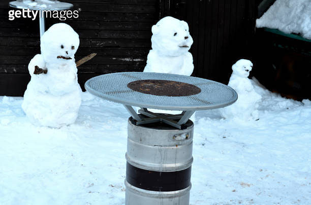 snowmen at a table made of tin beer barrels. it looks like a nice party ...