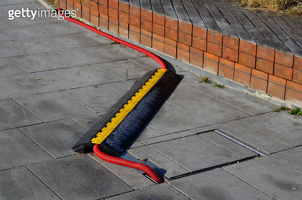 connecting electricity cables through walking paved sidewalk road. safe ...