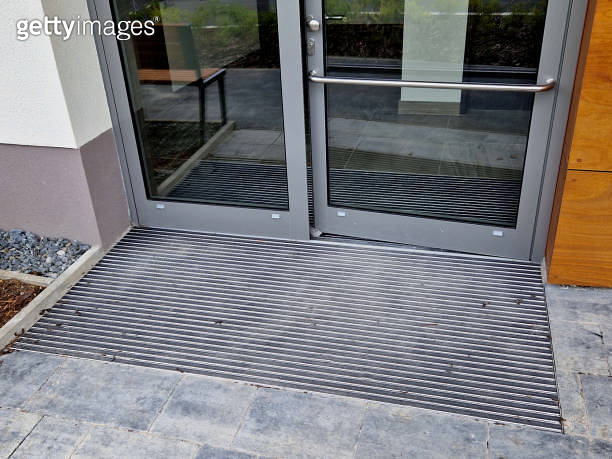 industrial mat cleaning zones at the entrance to the building. A black ...