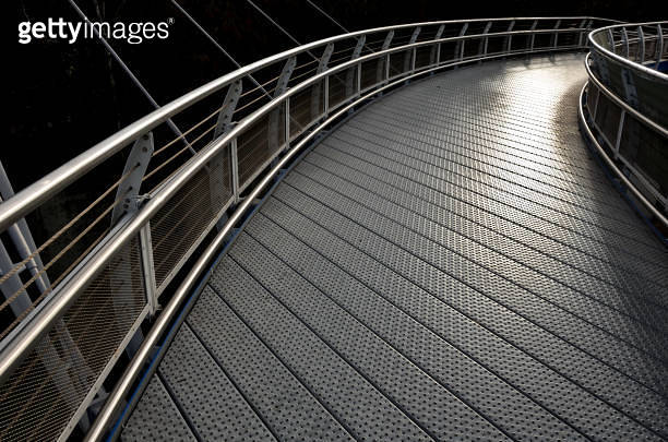 staircase and wide pedestrian bridge with perforated metal floor ...
