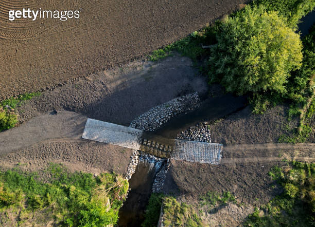 The dirt road leads across a stream that crosses river and continues ...