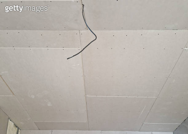 installation of a plasterboard ceiling. plaster is glued with paper and ...