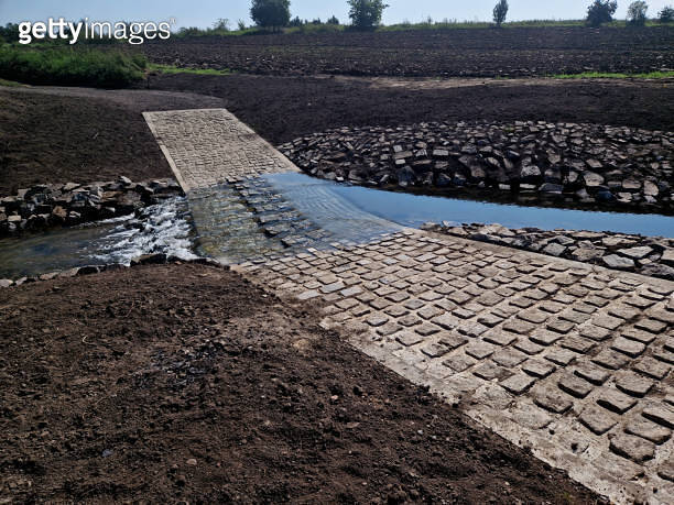 The dirt road leads across a stream that crosses river and continues ...