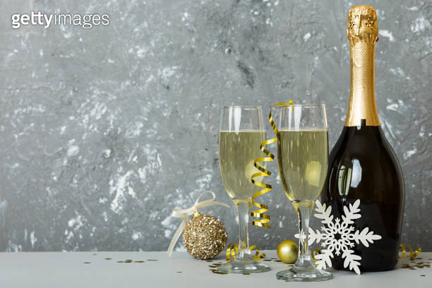 Champagne bottle with confetti, glasses and christmas decor on colored ...