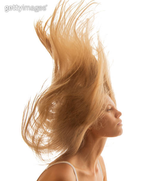 young woman in back light with flying hair 이미지 (1733938749) - 게티이미지뱅크