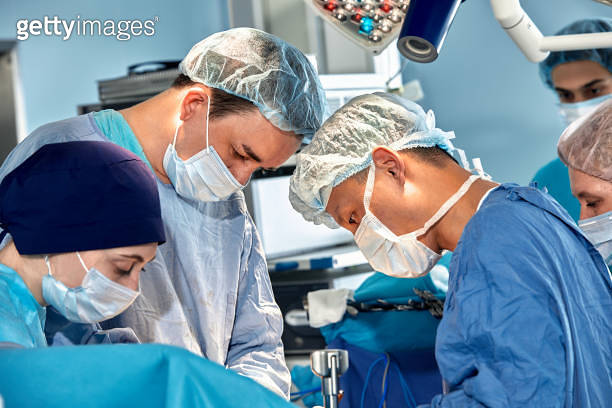 Surgeons team during complex surgical operation in a sterile operating ...