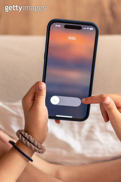 Close up of child hands holding phone with Dad's incoming call on ...