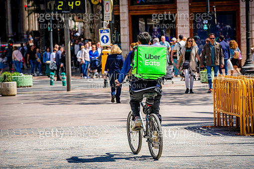 Rear view of UBER EATS rider with backpack delivering food 이미지 ...