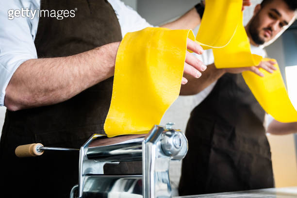 Fresh pasta and pasta machine. Italian traditional tagliatelle. Young ...