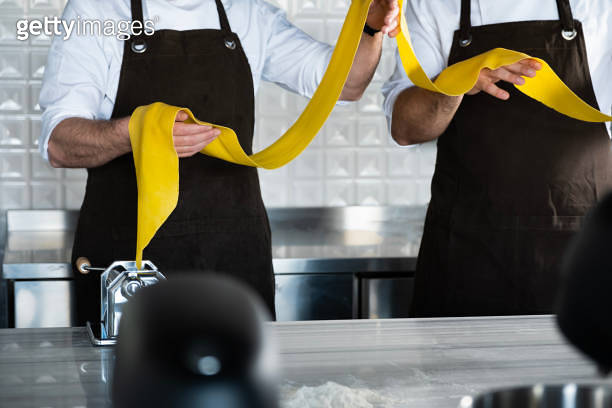 Fresh pasta and pasta machine. Italian traditional tagliatelle. Young ...