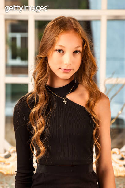 Portrait of perfect teen model girl 14 year old posing at large window ...