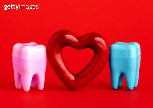 Pink and blue tooth and red heart on red background. Oral care and St ...