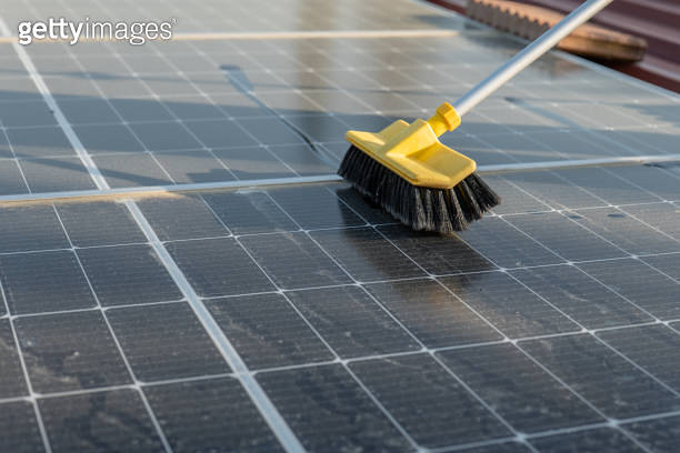 washing solar panels from dust and dirt on the roof with water close-up ...