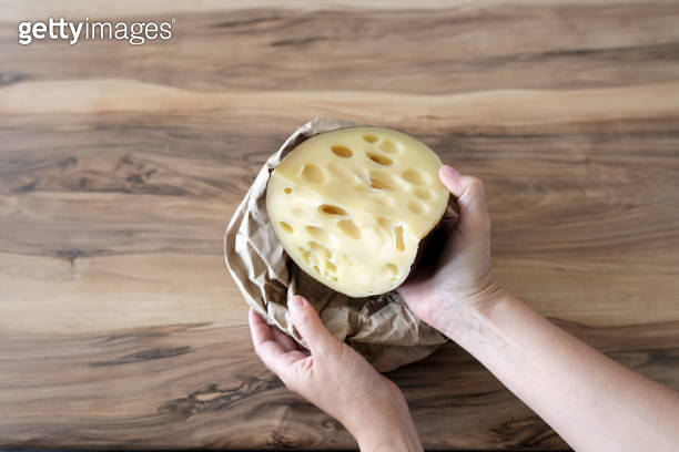 closeup of hand holding a piece of elemental cheese. (1503215950) - 게티이미지뱅크