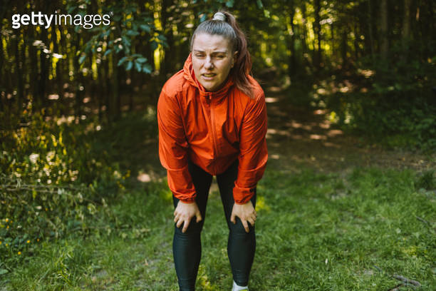 Tired female runner suffering with pain on sports running knee injury ...
