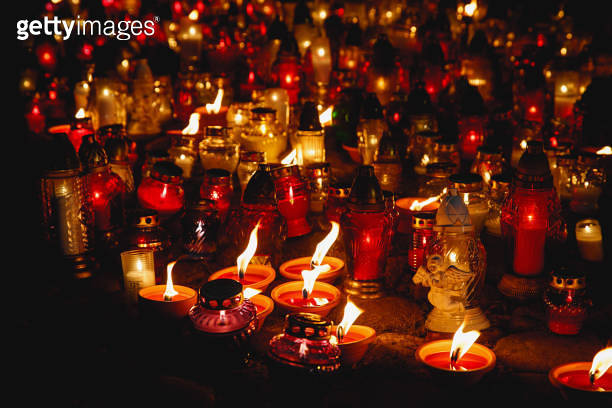 Many colorful lit memory candles in the dark. A beautiful display of ...