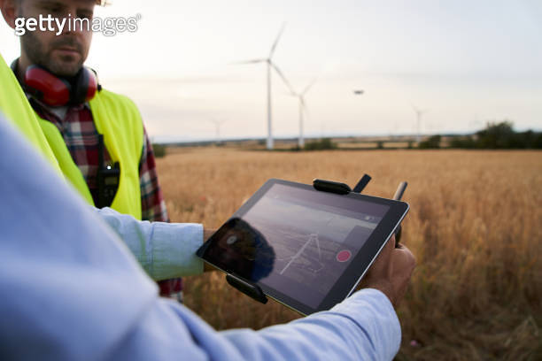 Close up of operator hands holding remote control and quad copter ...