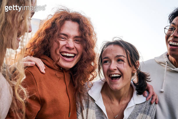 Portrait of group of four young students laughing out loud. Friends ...