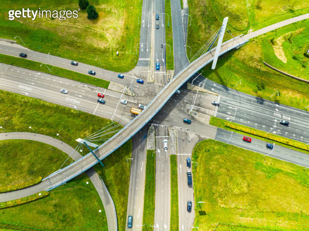 Traffic at a junction with a winding bicycle path bridge seen from ...