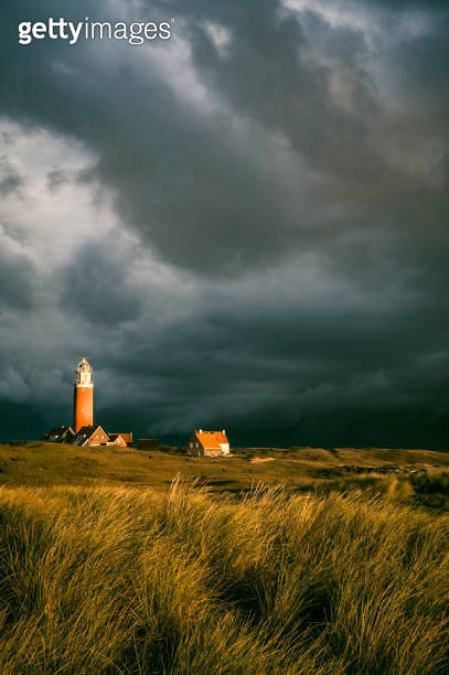 Texel lighthouse in the dunes during a stormy autumn night 이미지 ...