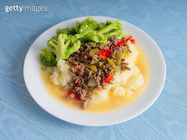 Scrambled hamburger on mashed potatoes with steamed broccoli ...