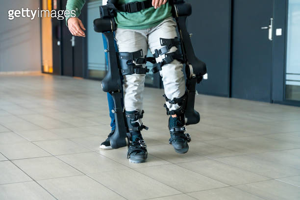 Mechanical exoskeleton, physiotherapist walking with unrecognizable ...