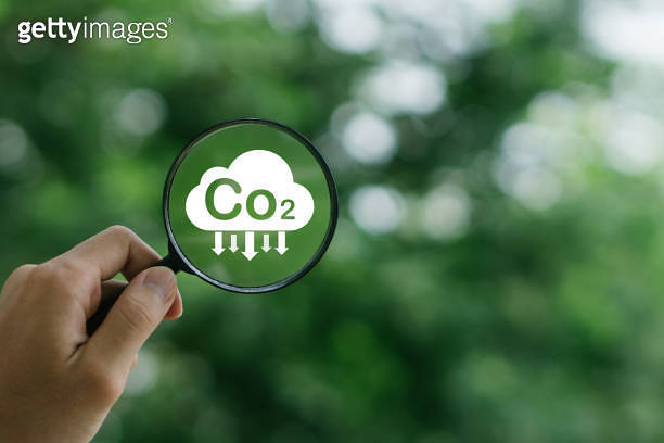 CO2 reducing icon inside magnifier glass on greenery background,global warming for environmental ...