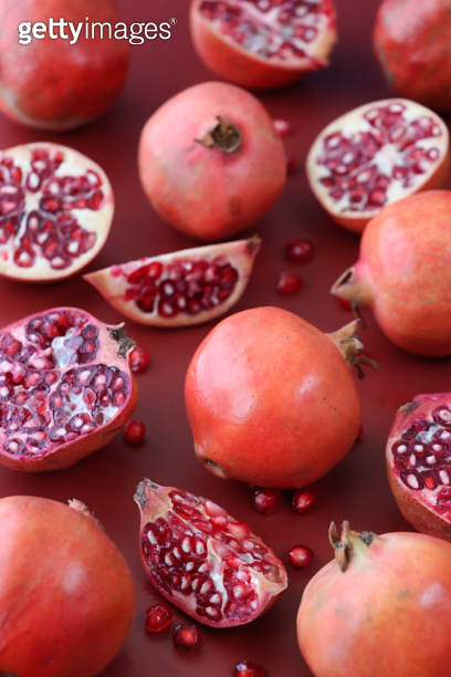Full frame image of pomegranates (Punica granatum), whole, halved and ...