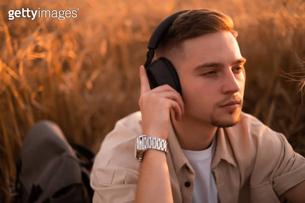 Relaxed man breathes fresh air and meditates while listening to audio ...