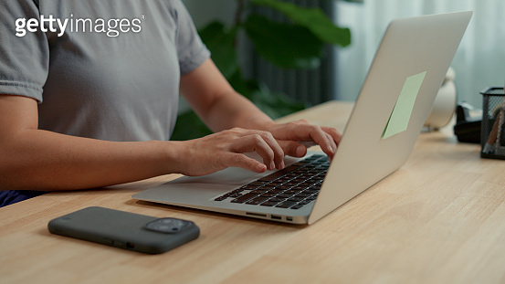 Asian woman happy typing on keyboard using laptop for work at home ...