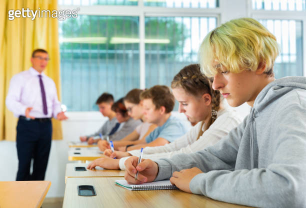 Teenage high school students diligently working in class 이미지 ...