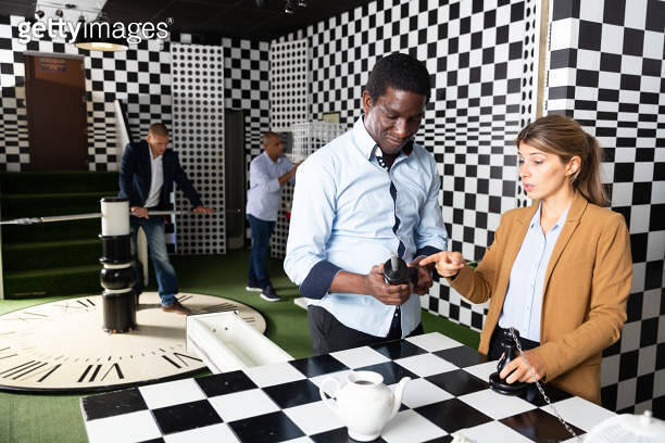 Colleagues playing in chess quest room during team building (1490151505 ...