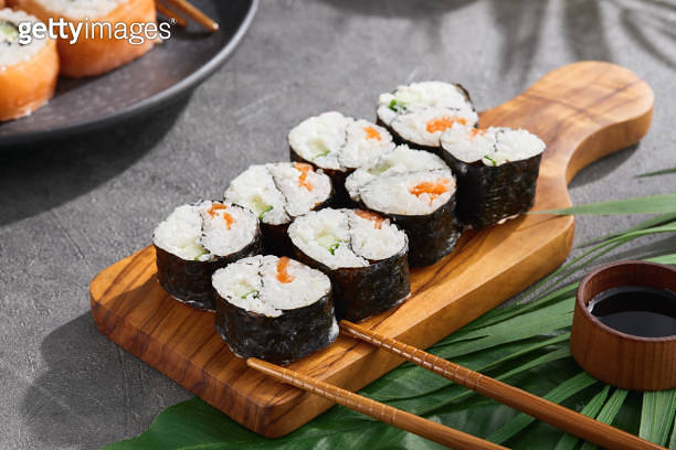 Simple roll yin yang maki on wood on gray stone background. Maki sushi ...