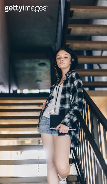 Transgender non-binary teenager with cool attitude, headphones and ...