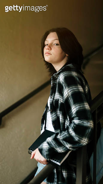 Transgender non-binary teenager with cool attitude, headphones and ...